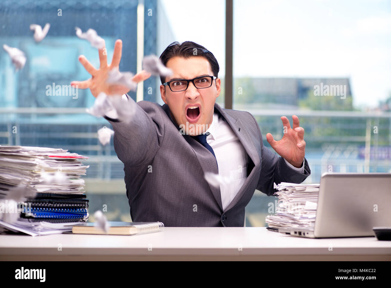 Angry businessman with too much work in office Stock Photo - Alamy