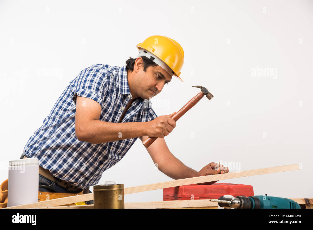 Handsome Indian Carpenter or wood worker in action, isolated over white ...