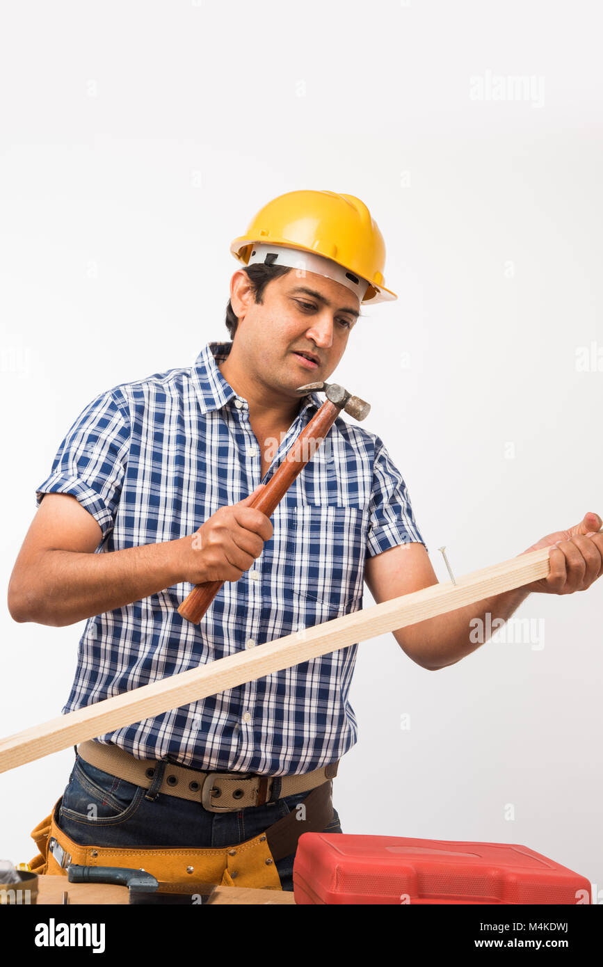 Handsome Indian Carpenter or wood worker in action, isolated over white ...