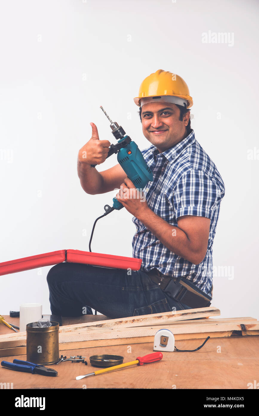 Handsome Indian Carpenter or wood worker in action, isolated over white ...