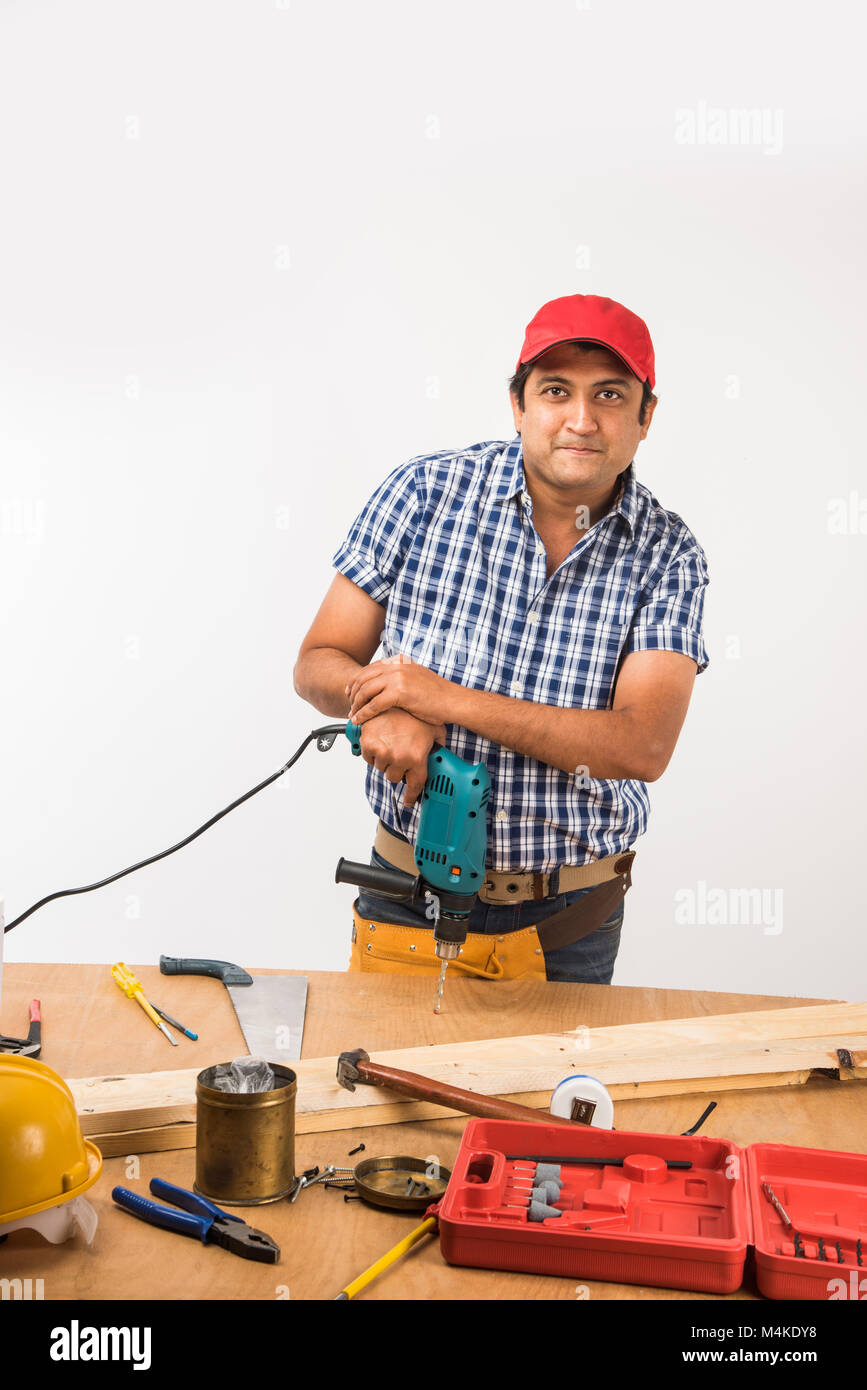 Handsome Indian Carpenter or wood worker in action, isolated over white ...