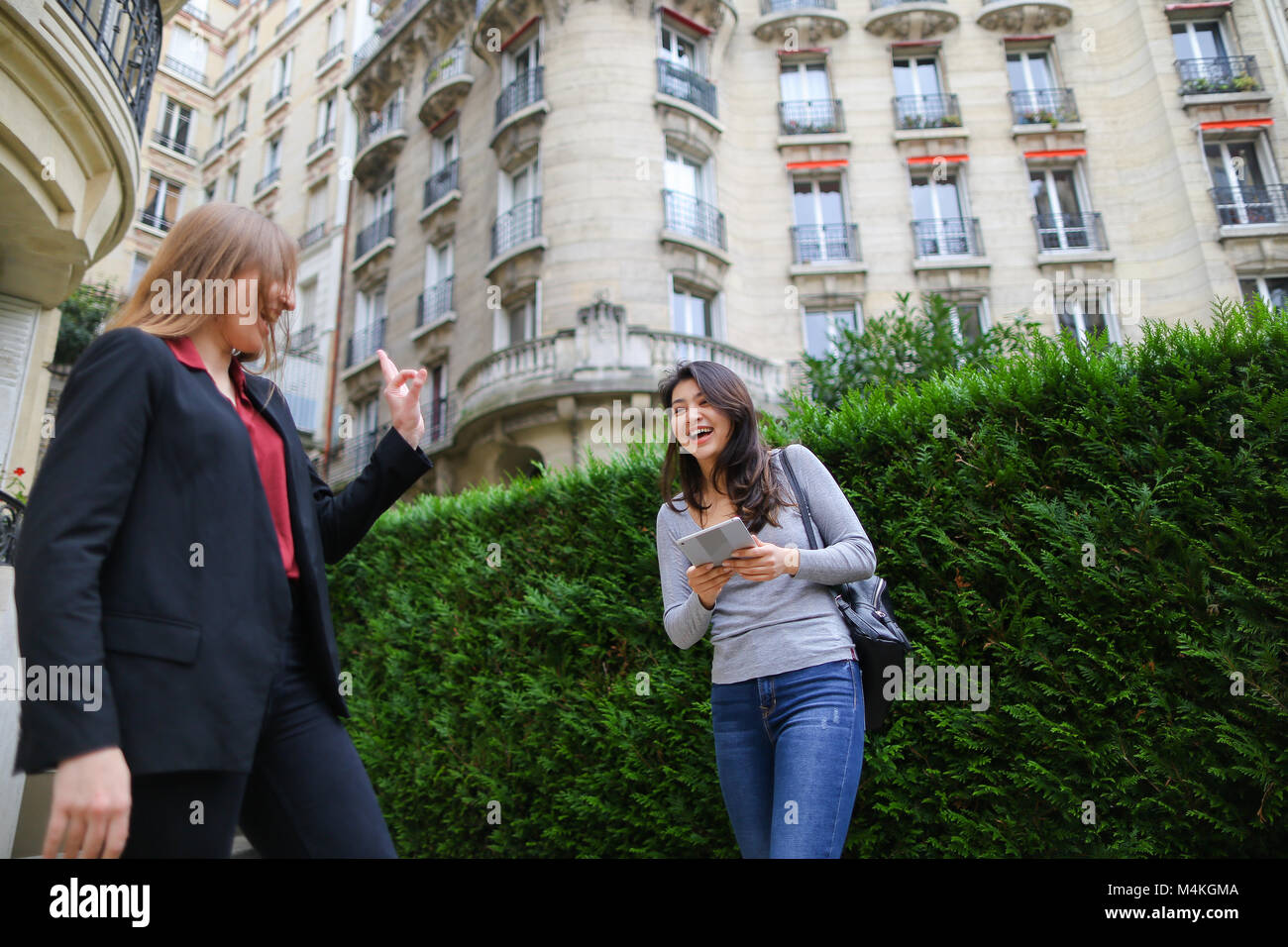 Beautiful girl talking with foreign Chinese student keeping tabl Stock ...