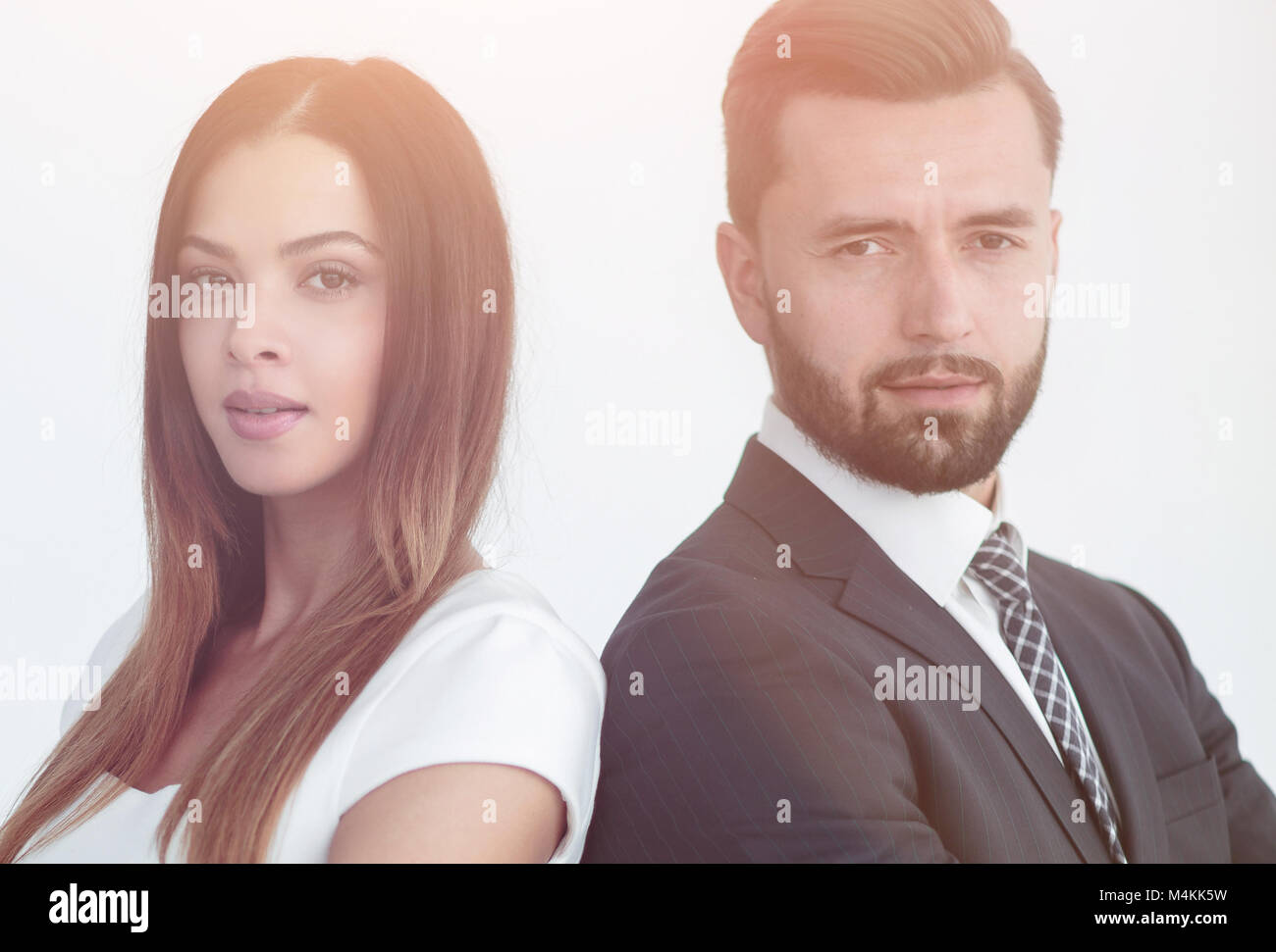 Portrait of young business coworker standing back to back over white ...