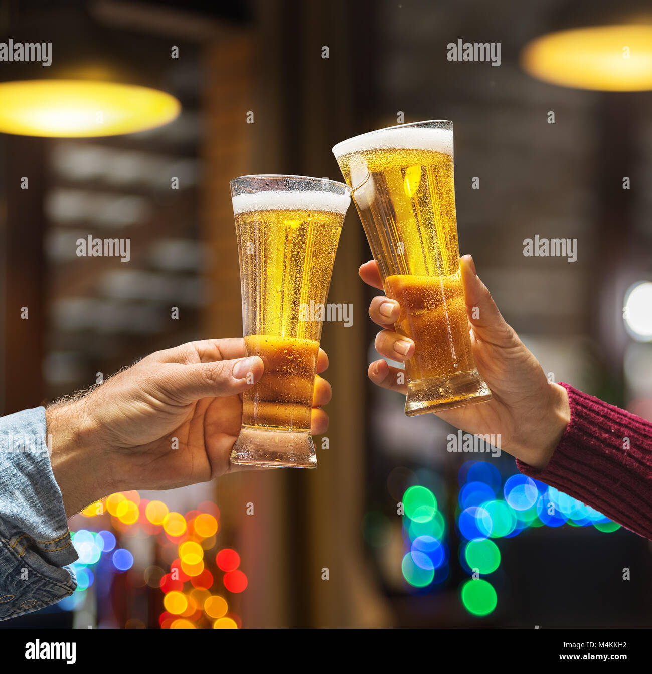 Beer glasses raised in a toast. Close-up hands with glasses. Blurred ...