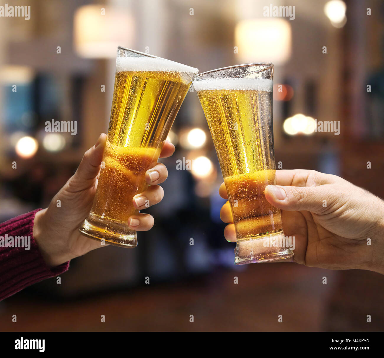 Beer glasses raised in a toast. Close-up hands with glasses. Blurred ...
