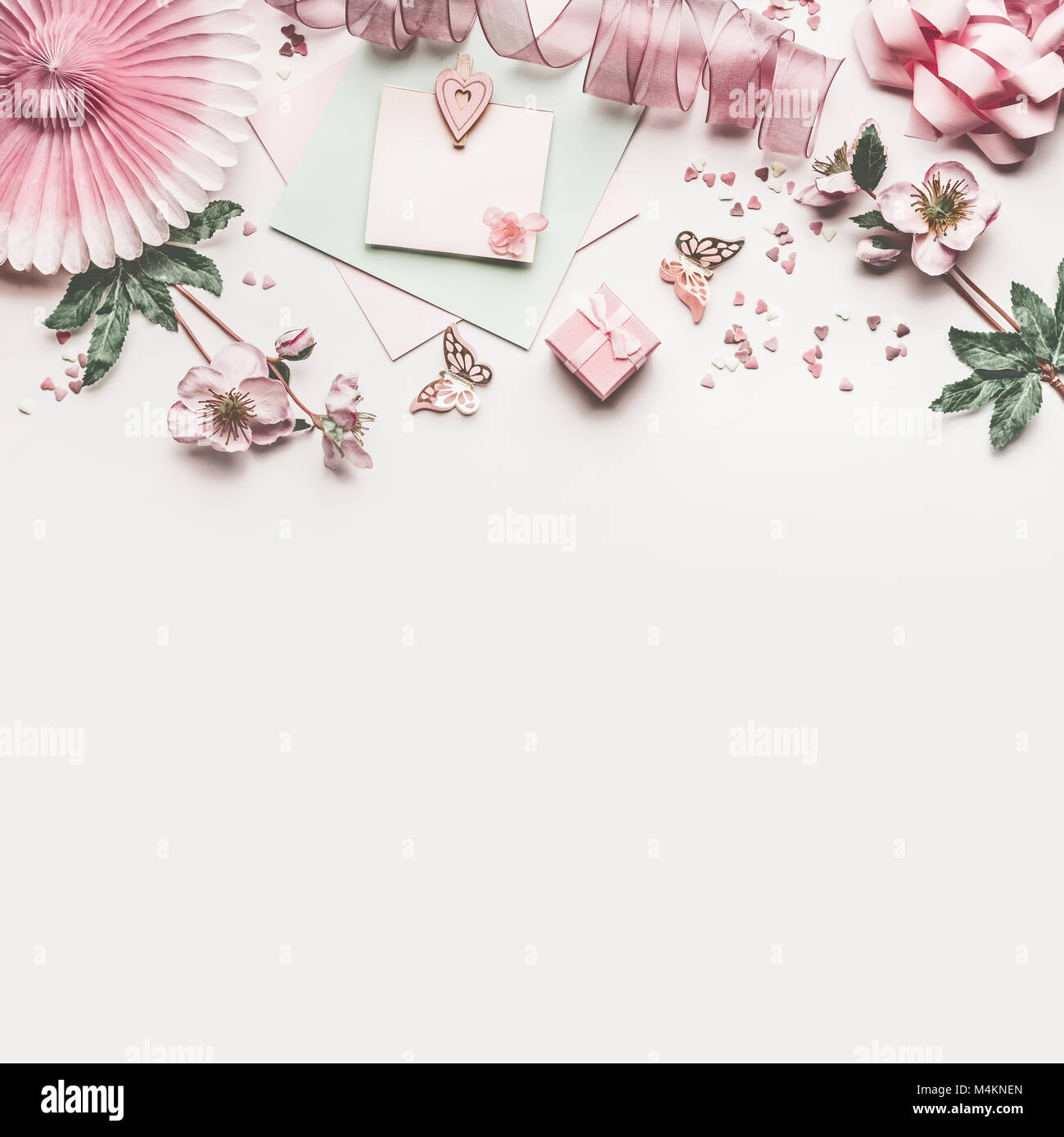 Beautiful pastel pink work space with flowers decoration,ribbon, hearts ...