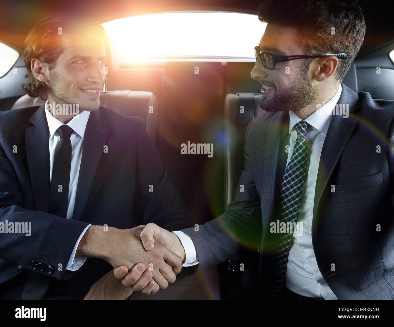 handshake of business partners sitting in prestigious cars Stock Photo ...