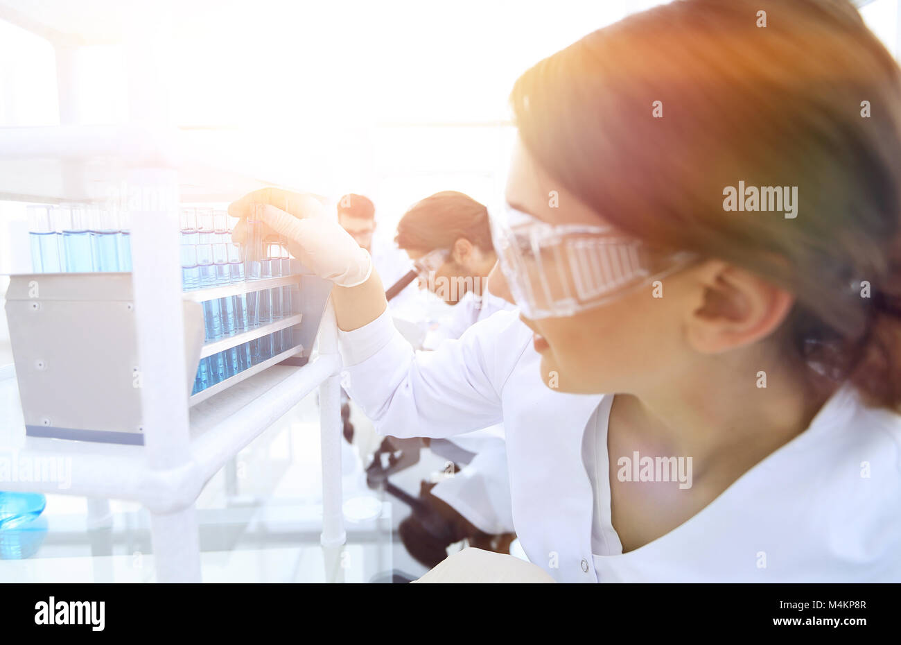 attractive young student scientist observing the blue indicator color ...