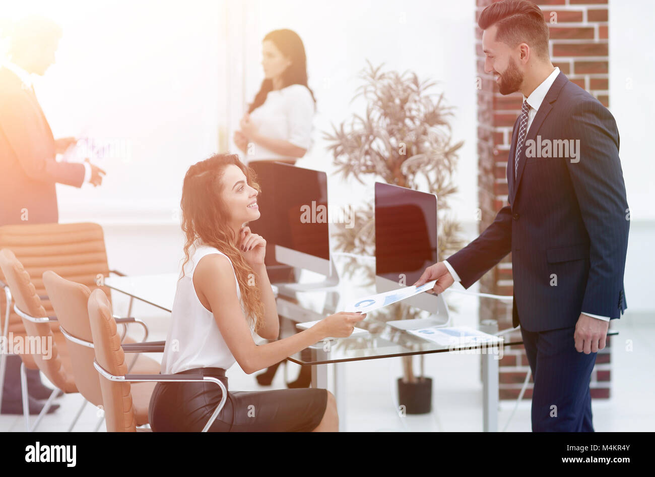 Manager handing the employee the document.office life Stock Photo - Alamy