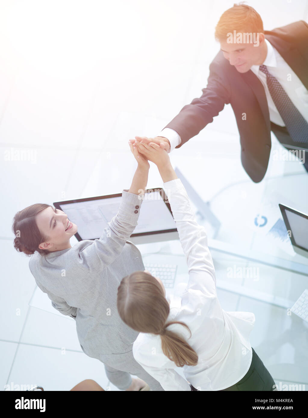 members of the business team giving each other a high five above the ...