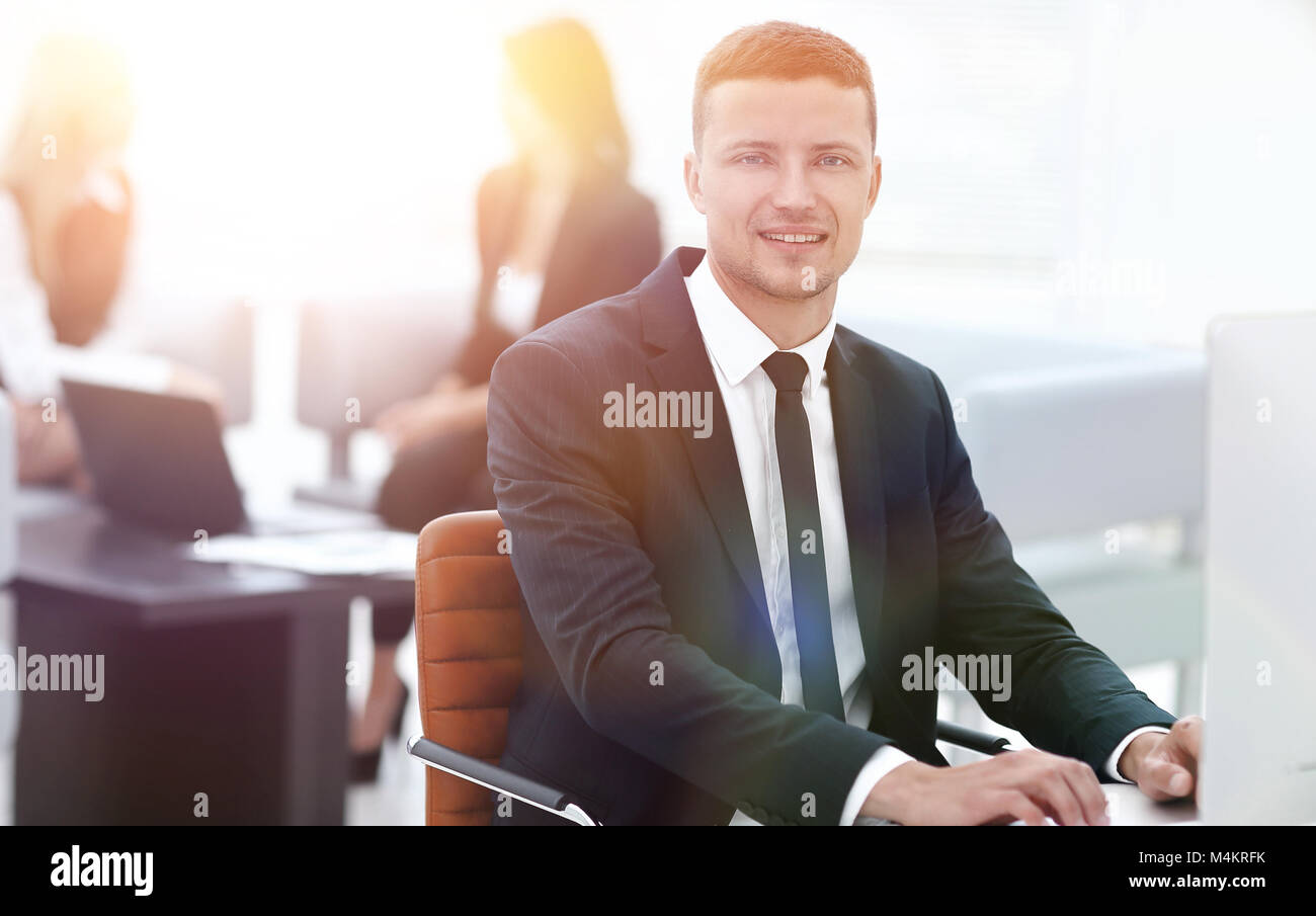 portrait of a successful businessman sitting behind a Desk in the ...