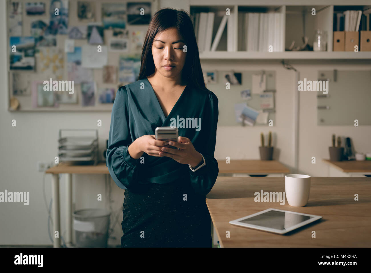 Executive using mobile phone in office Stock Photo - Alamy