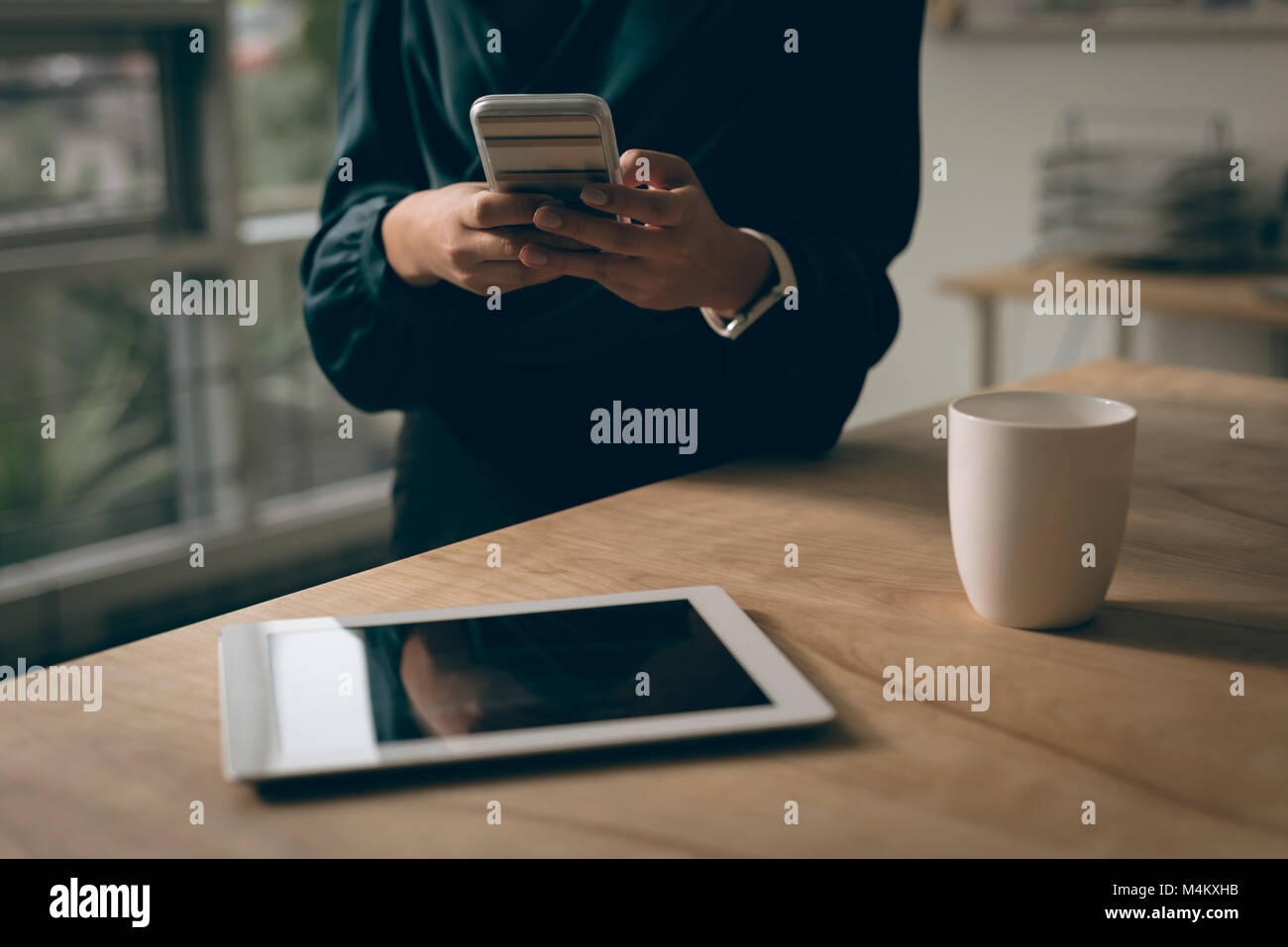 Executive using mobile phone in office Stock Photo - Alamy