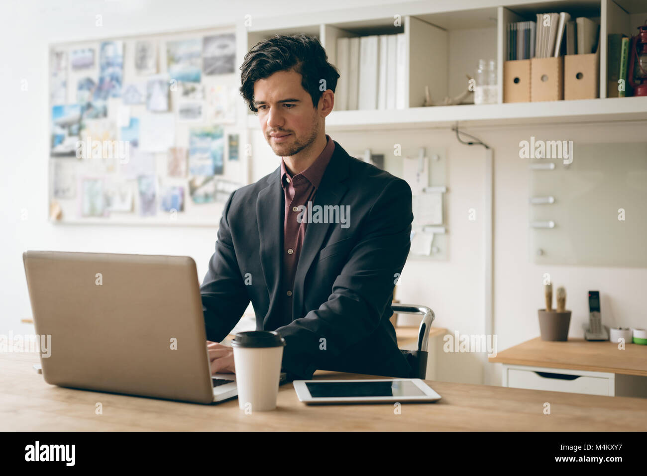 Executive working on laptop in office Stock Photo - Alamy