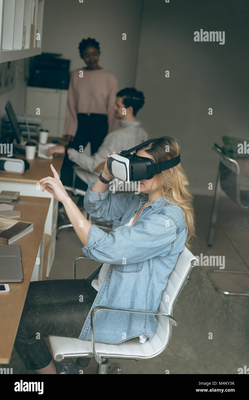 Female executive using virtual reality headset Stock Photo - Alamy