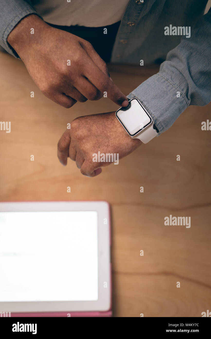 Executive using smartwatch in office Stock Photo - Alamy