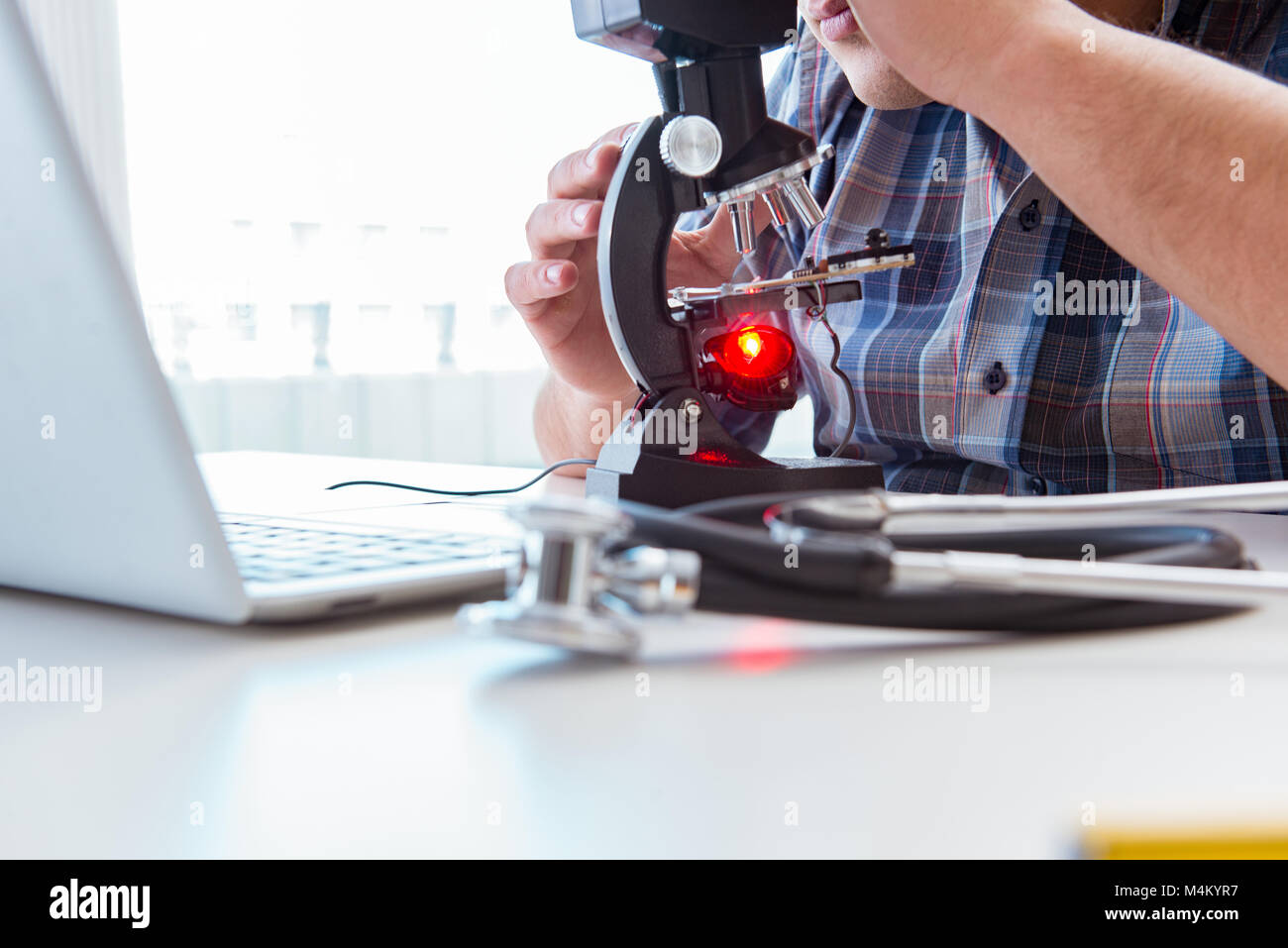 High precision engineering with man working with microscope Stock Photo ...