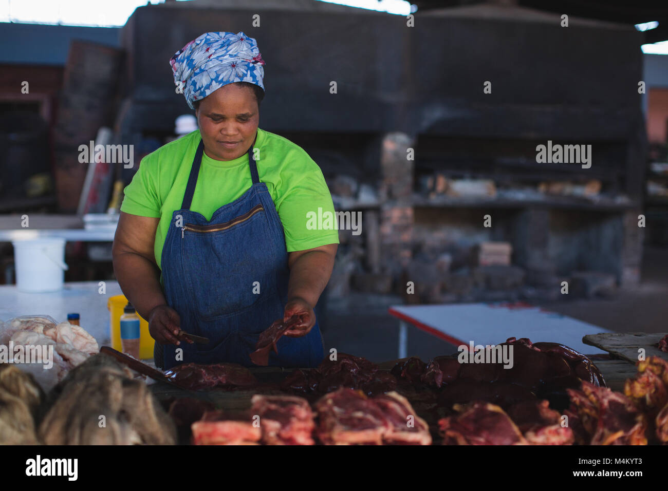 Butcher cutting meat at counter in butchery Stock Photo - Alamy