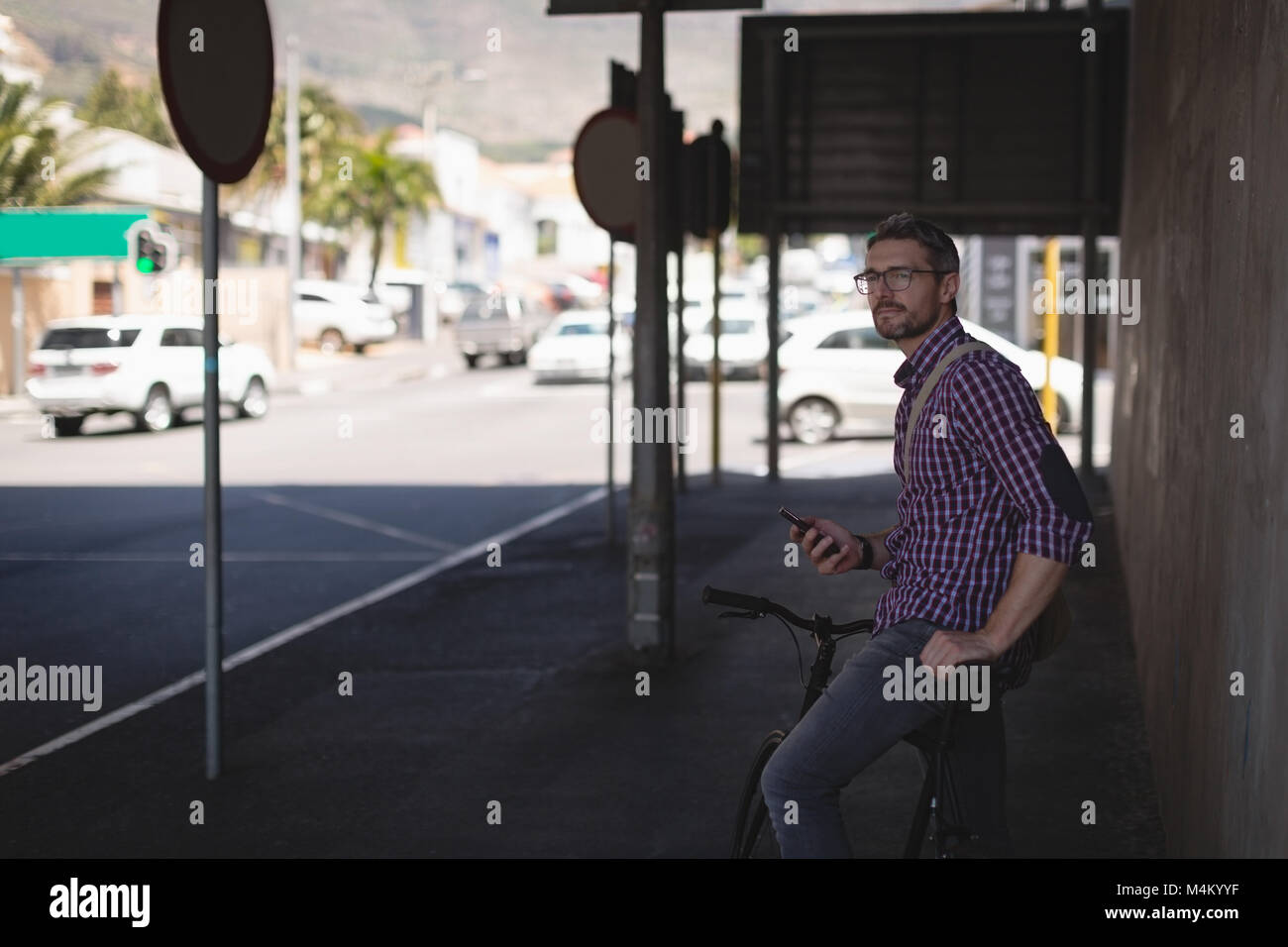 Man with mobile phone standing on sidewalk Stock Photo - Alamy