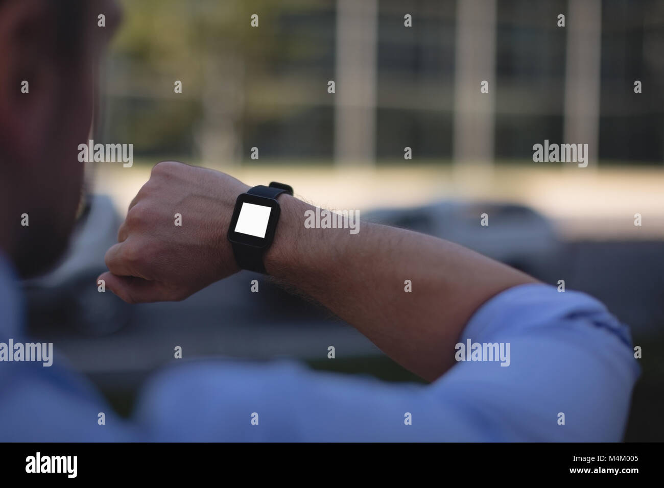 Man looking at smartwatch Stock Photo - Alamy