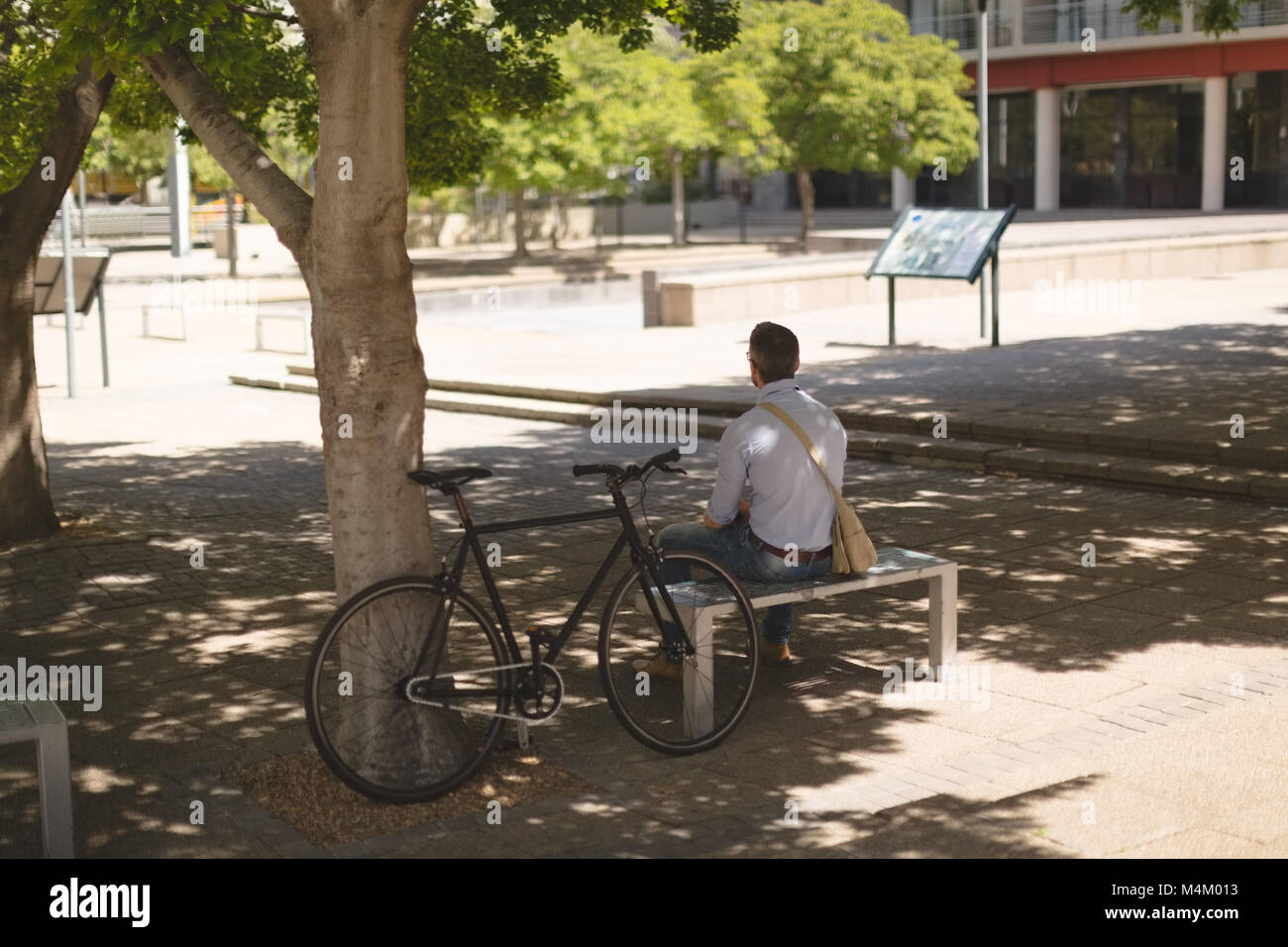 Man sitting on bench in park Stock Photo - Alamy