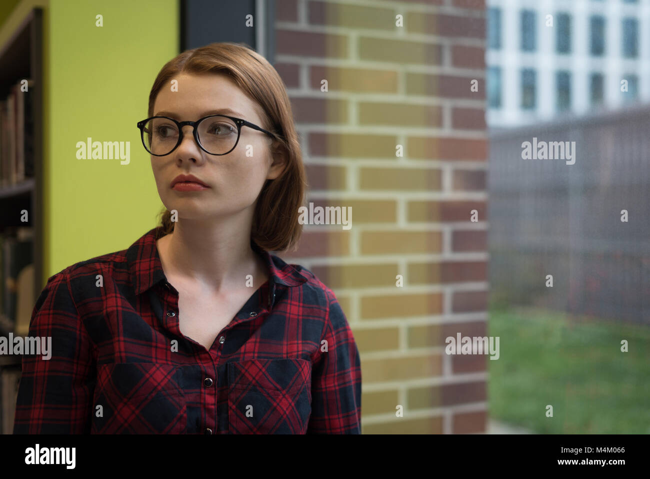 Woman standing in the library Stock Photo - Alamy