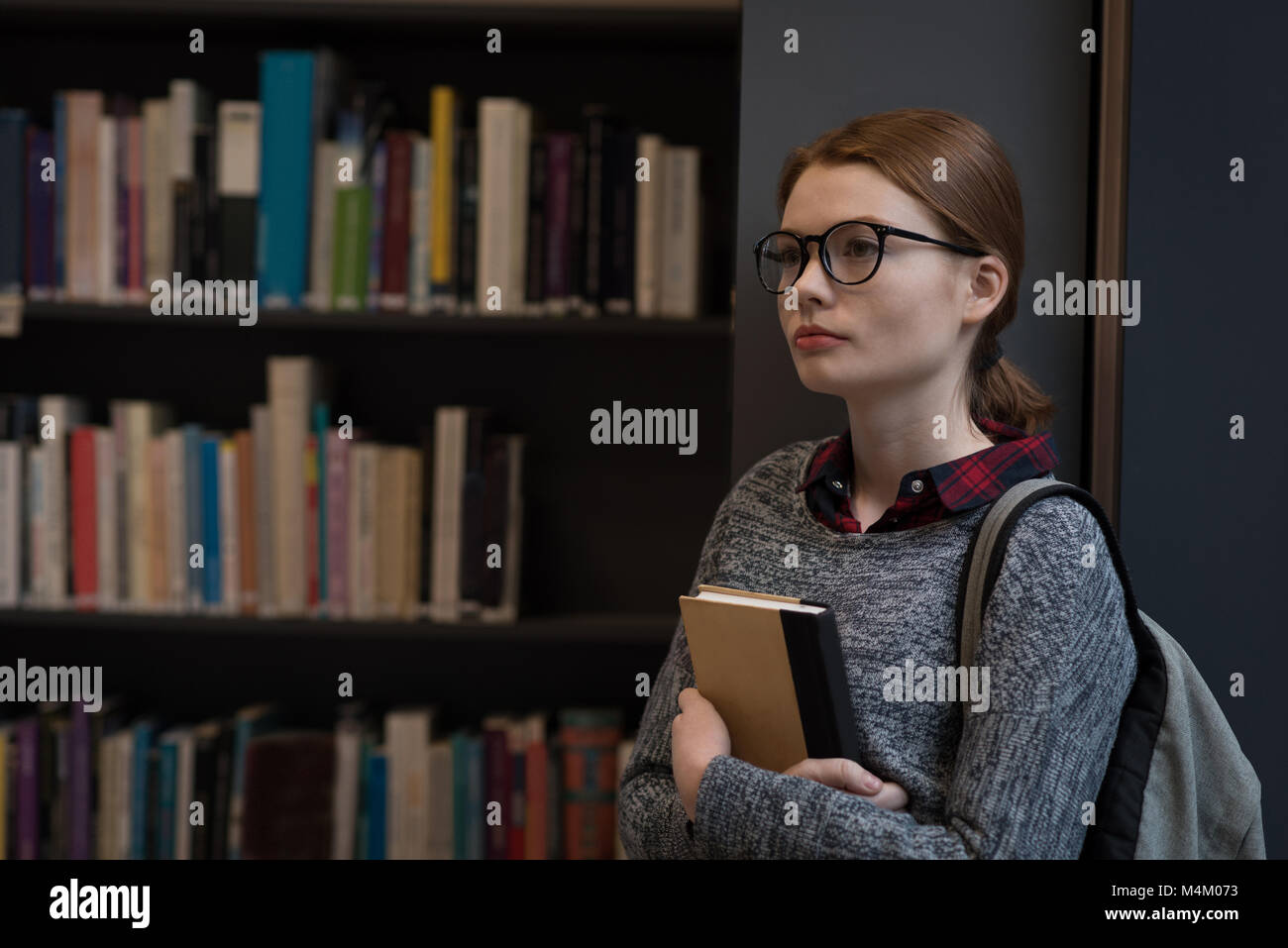 Young woman holding book bag hi-res stock photography and images - Alamy