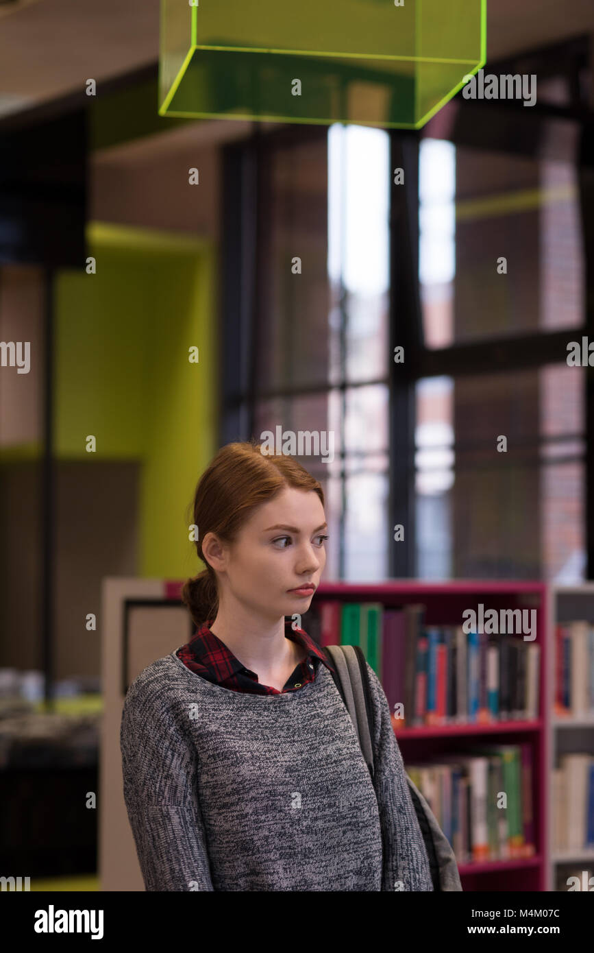 Woman standing in the library Stock Photo - Alamy
