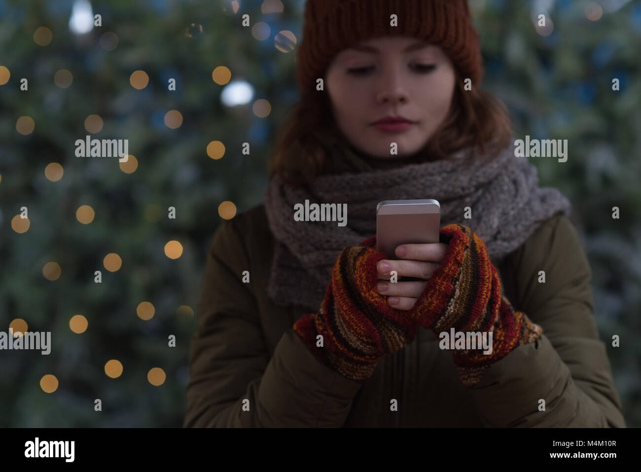 Woman in winter clothing using mobile phone Stock Photo - Alamy