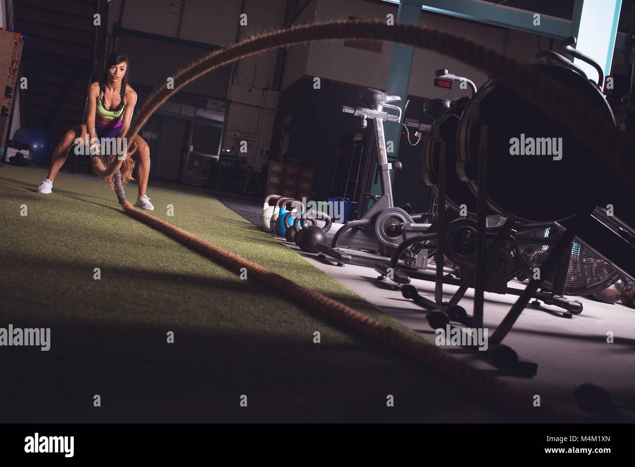 Fit woman doing battle rope exercise Stock Photo - Alamy