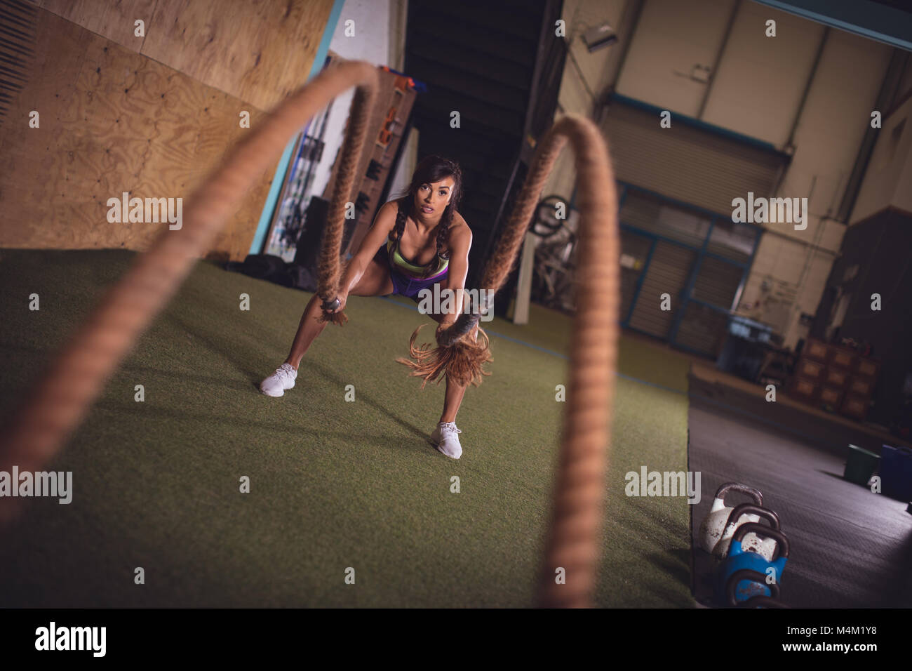 Fit woman doing battle rope exercise Stock Photo - Alamy