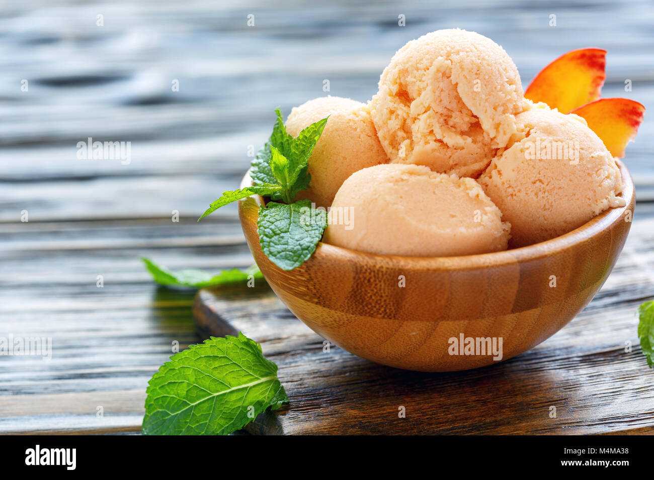 Balls peach ice cream in a wooden bowl Stock Photo - Alamy