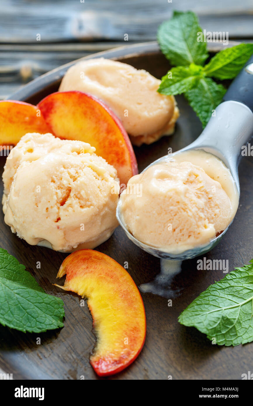 Peach ice cream spoon, peach pieces and mint leaves Stock Photo - Alamy