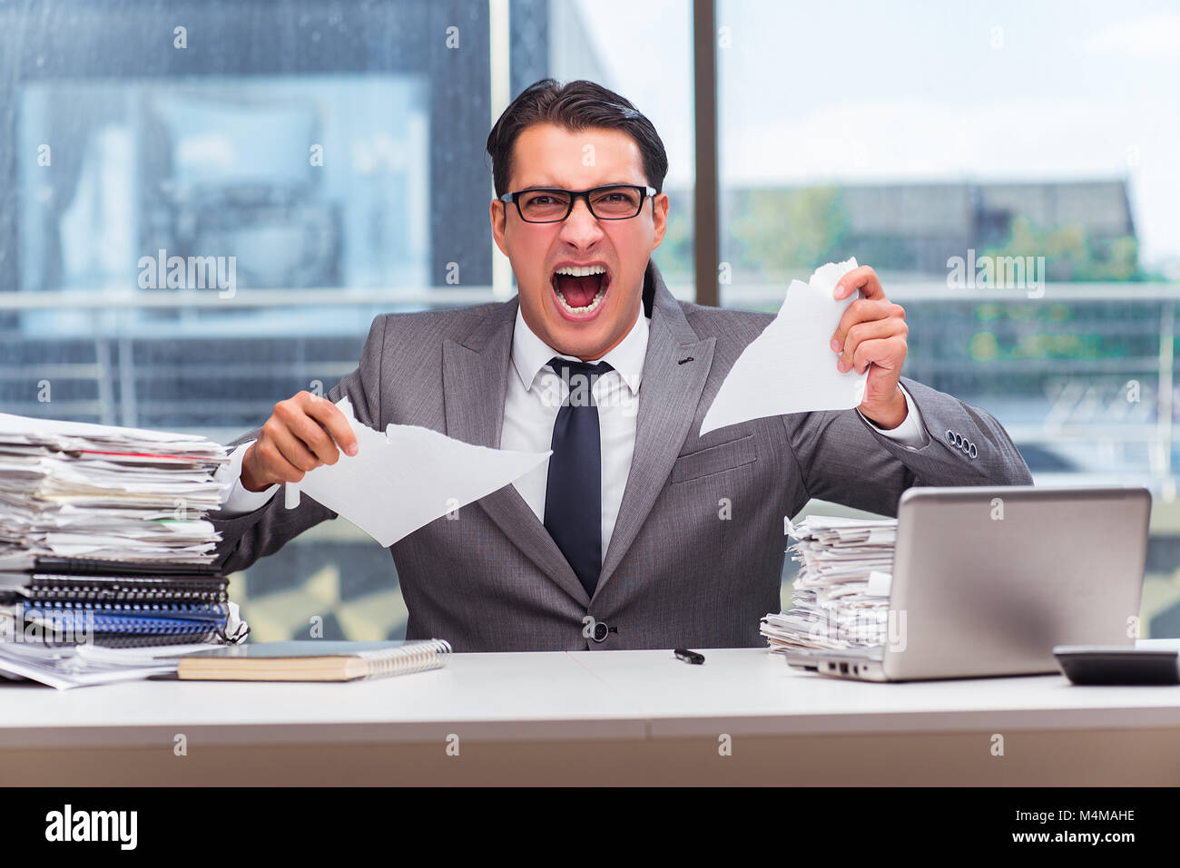 Angry businessman with too much work in office Stock Photo - Alamy