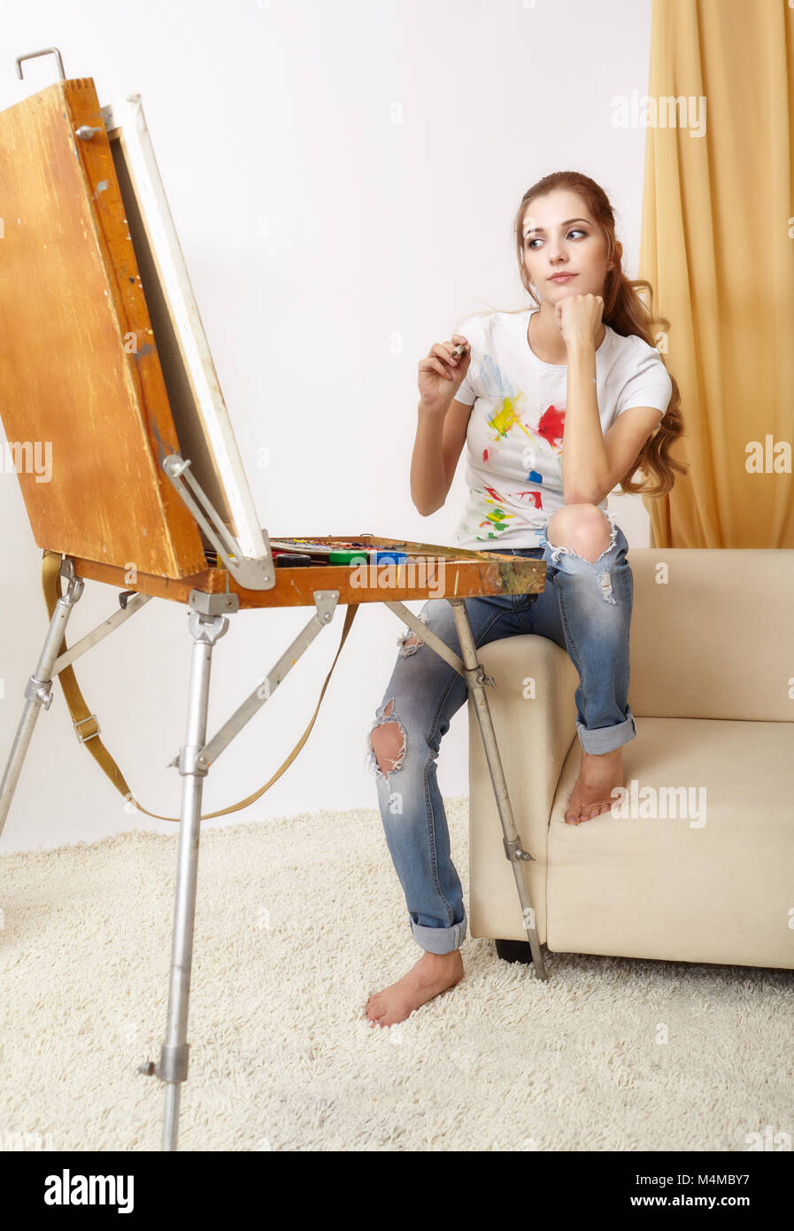 Painter female with wooden sketchbook sitting on sofa and painting ...