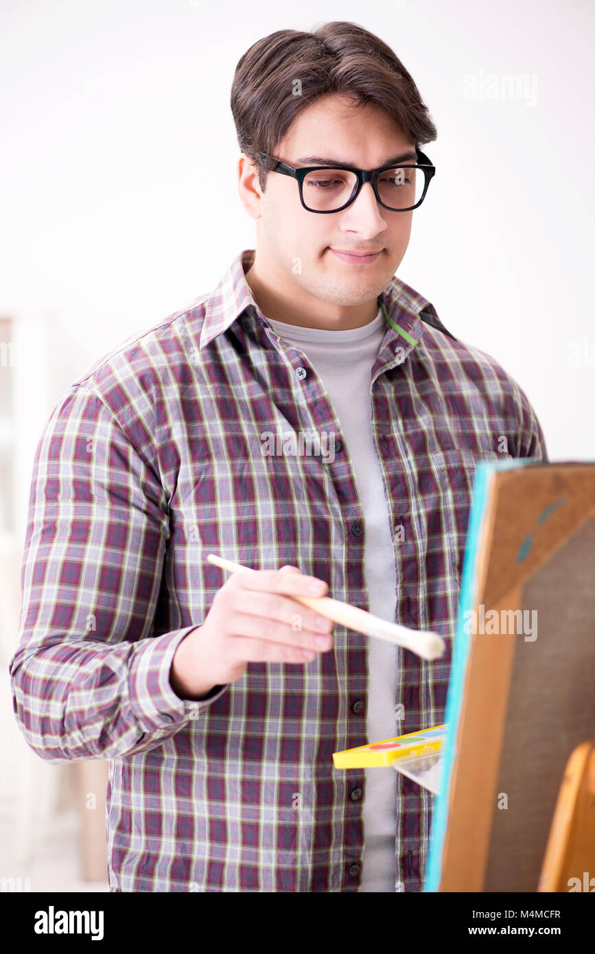 Young male artist drawing pictures in bright studio Stock Photo - Alamy