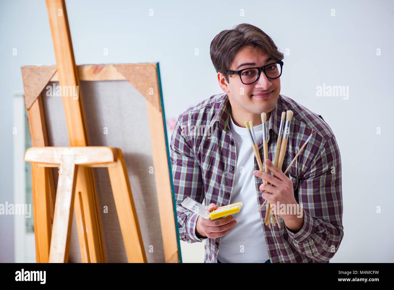Young male artist drawing pictures in bright studio Stock Photo - Alamy