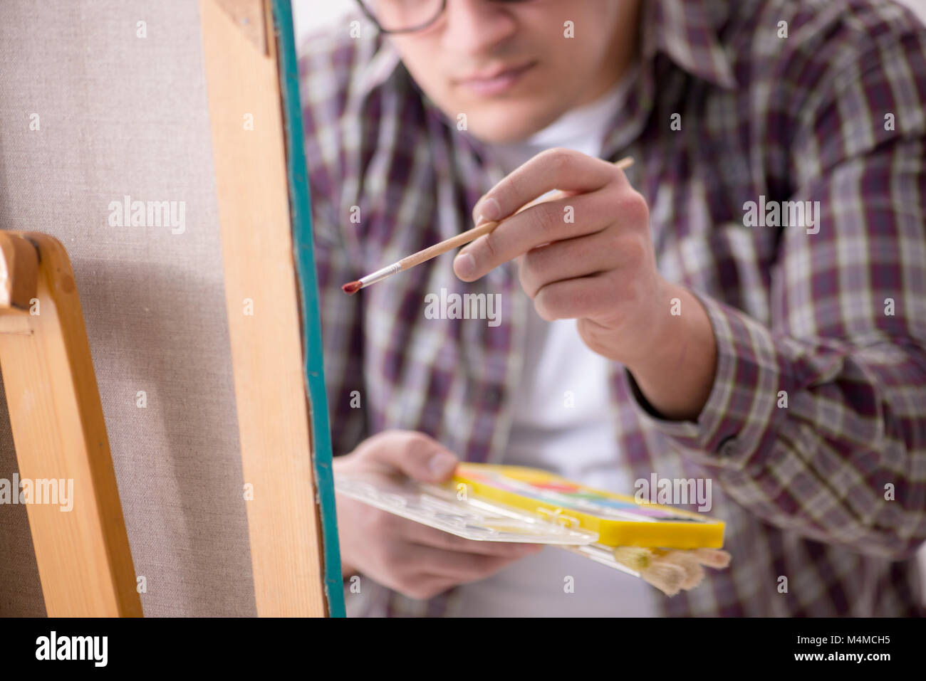 Young male artist drawing pictures in bright studio Stock Photo - Alamy