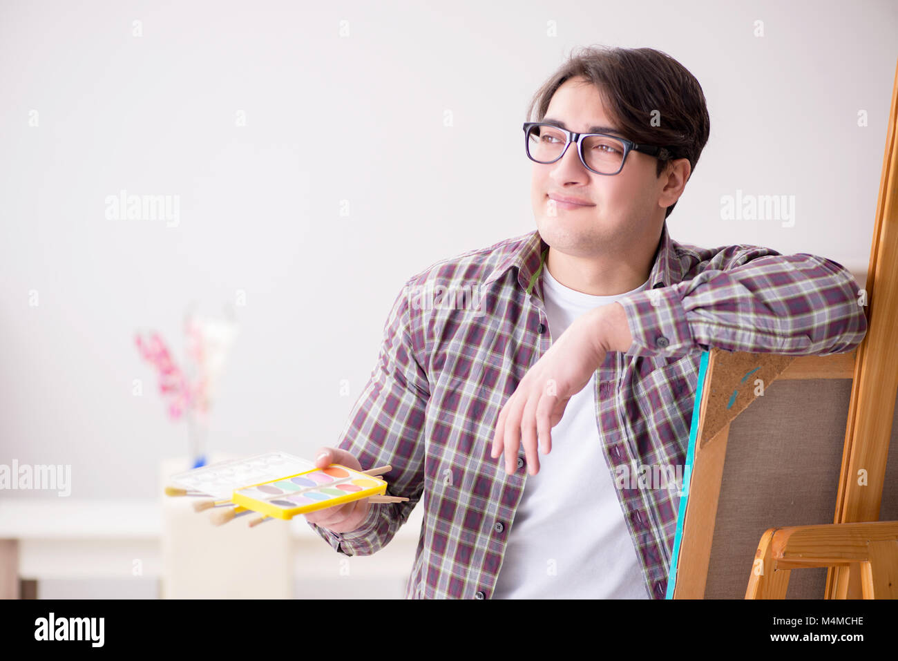Young male artist drawing pictures in bright studio Stock Photo - Alamy