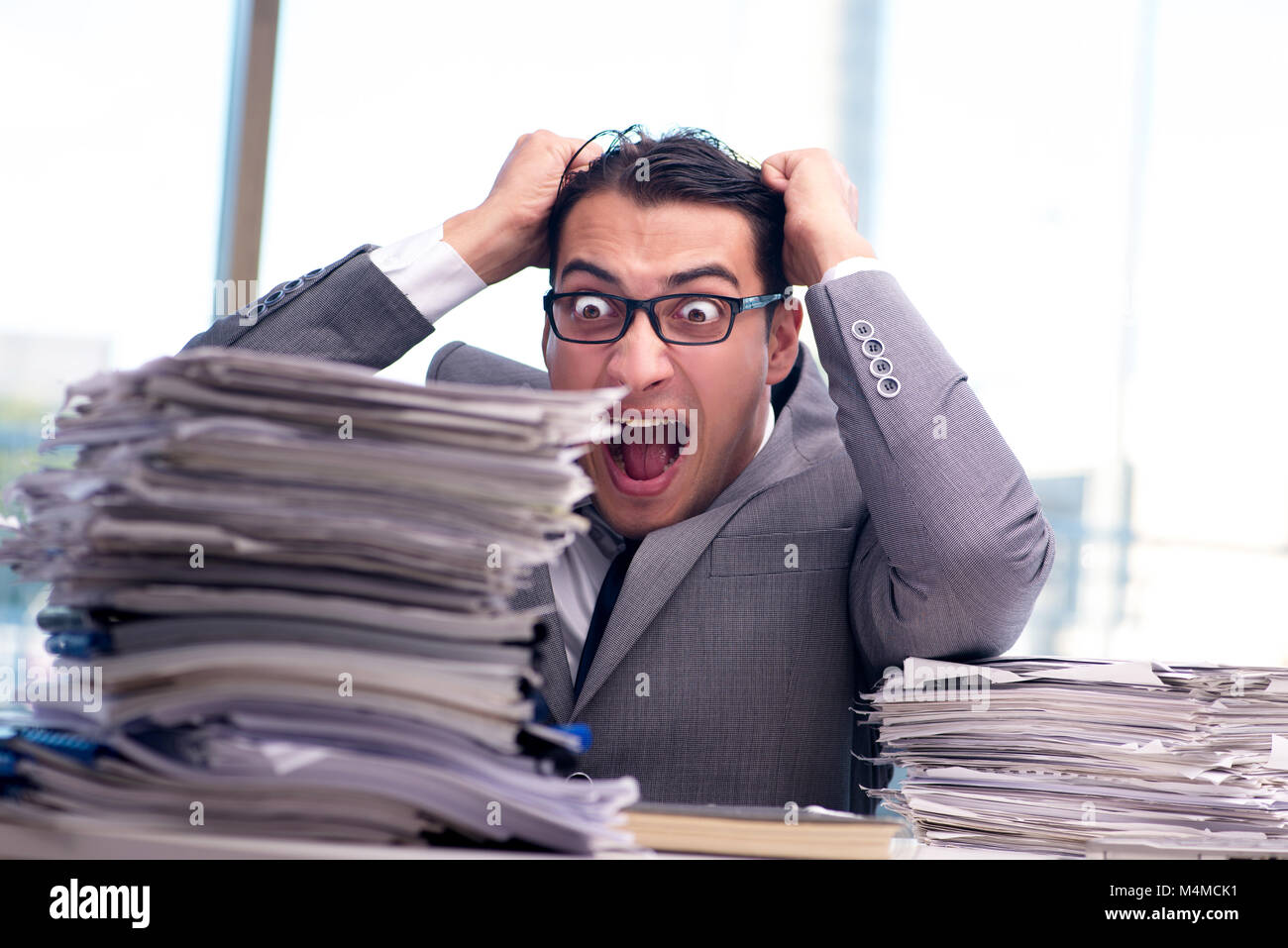 Busy angry businessman with heaps of paper Stock Photo - Alamy