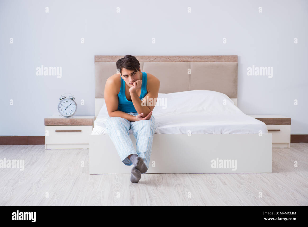 Young man waking up in bed Stock Photo - Alamy