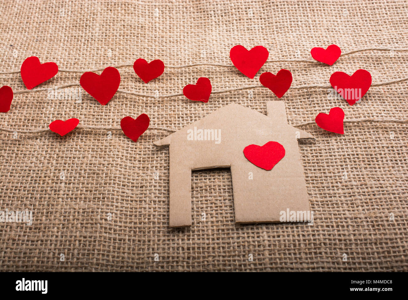 Heart shaped icons and paper house on linen threads Stock Photo - Alamy