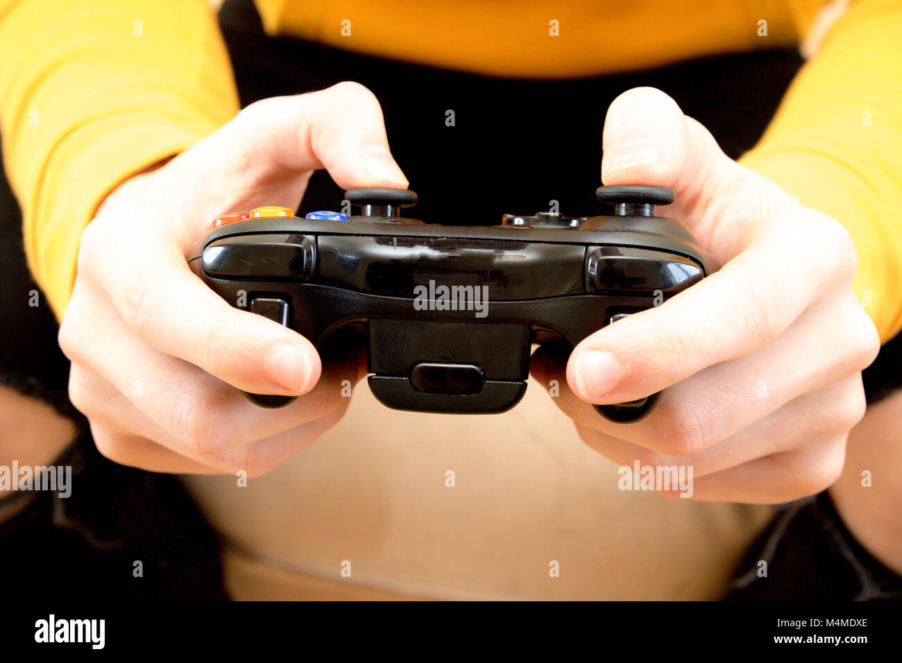 Teenage boy holding a video game console controller Stock Photo - Alamy