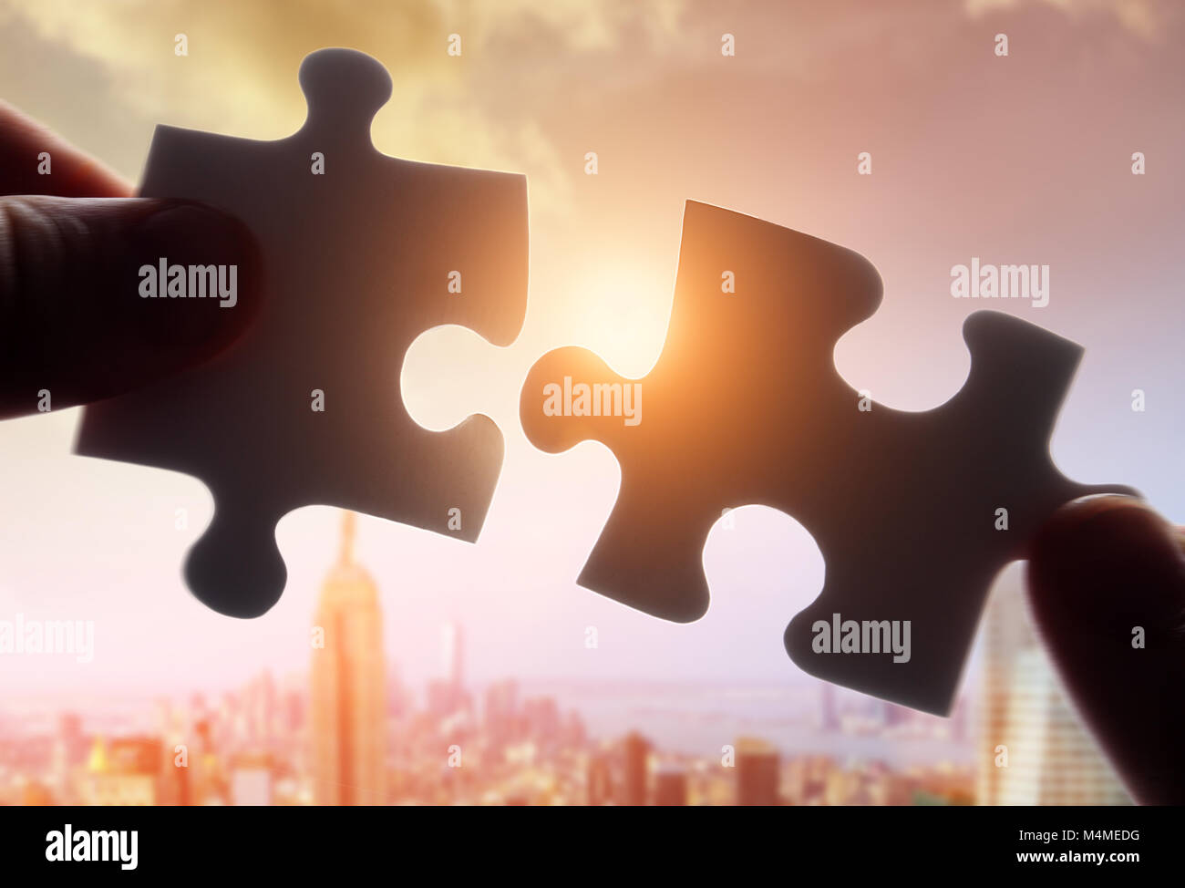 Putting puzzle pieces together on sky background with sunlight Stock ...