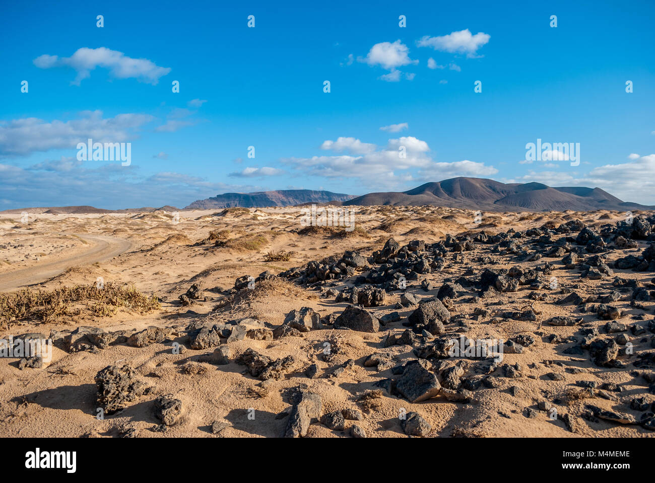 volcanic landscape with mountains in the background and red sand and ...
