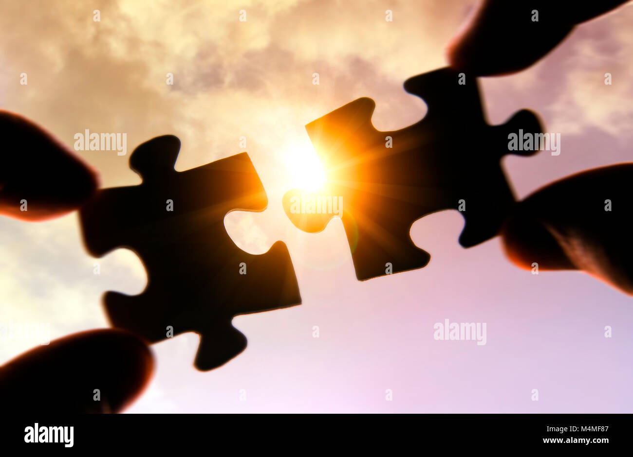 Putting puzzle pieces together on sky background with sunlight Stock ...