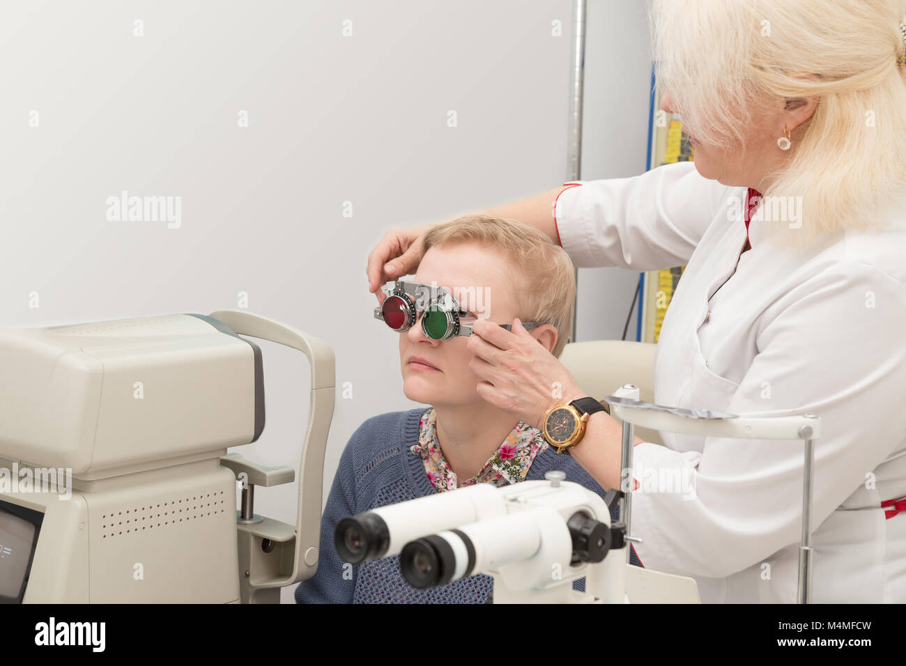 Oculist examines the vision of the patient with a red and green lens ...