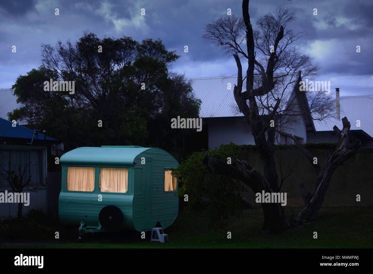 Old caravan at night with light shining through curtained windows Stock ...