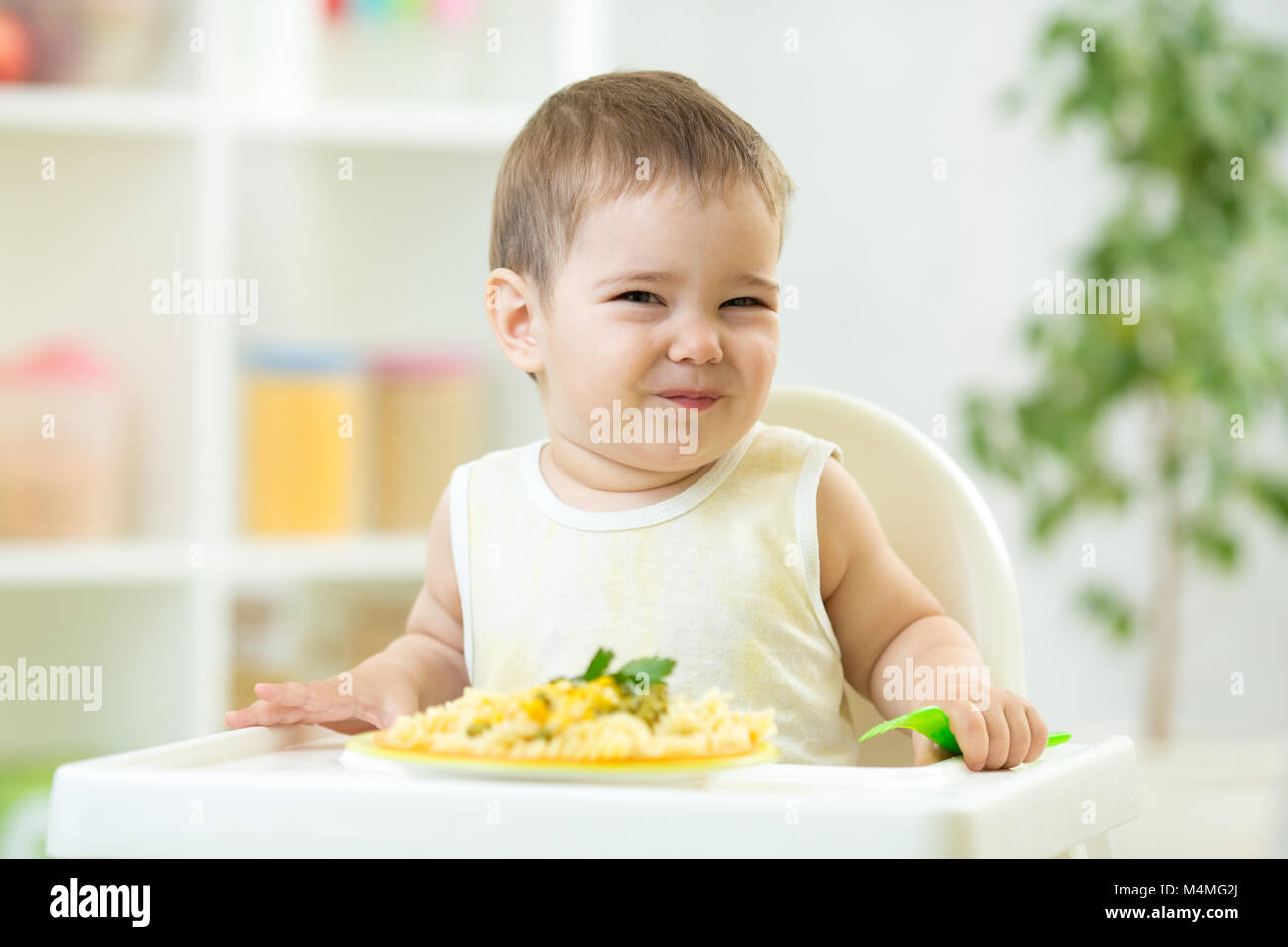 funny baby eating healthy food in daycare Stock Photo - Alamy