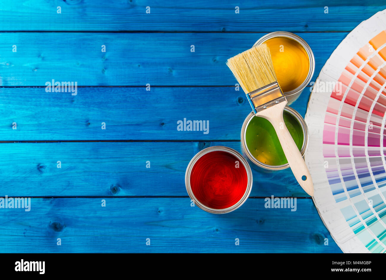 Paint cans color palette, cans opened with brushes on blue table Stock ...